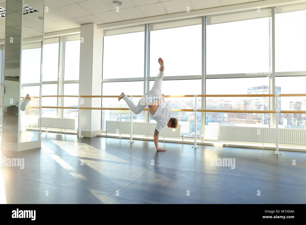 Gymnast in sportswear training near ballet barre in sport gym Stock ...