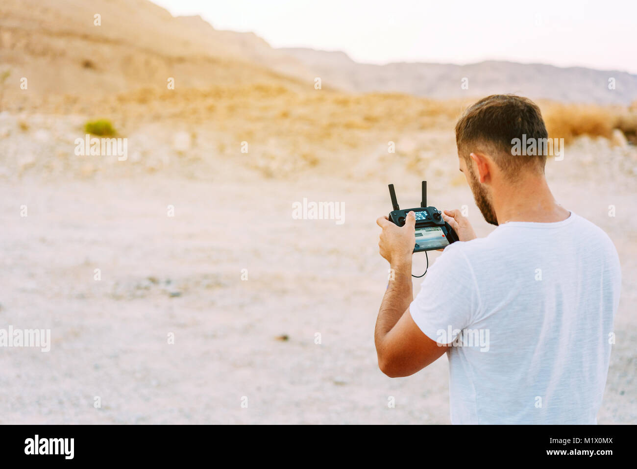 Guy controls drone with remote control Stock Photo - Alamy