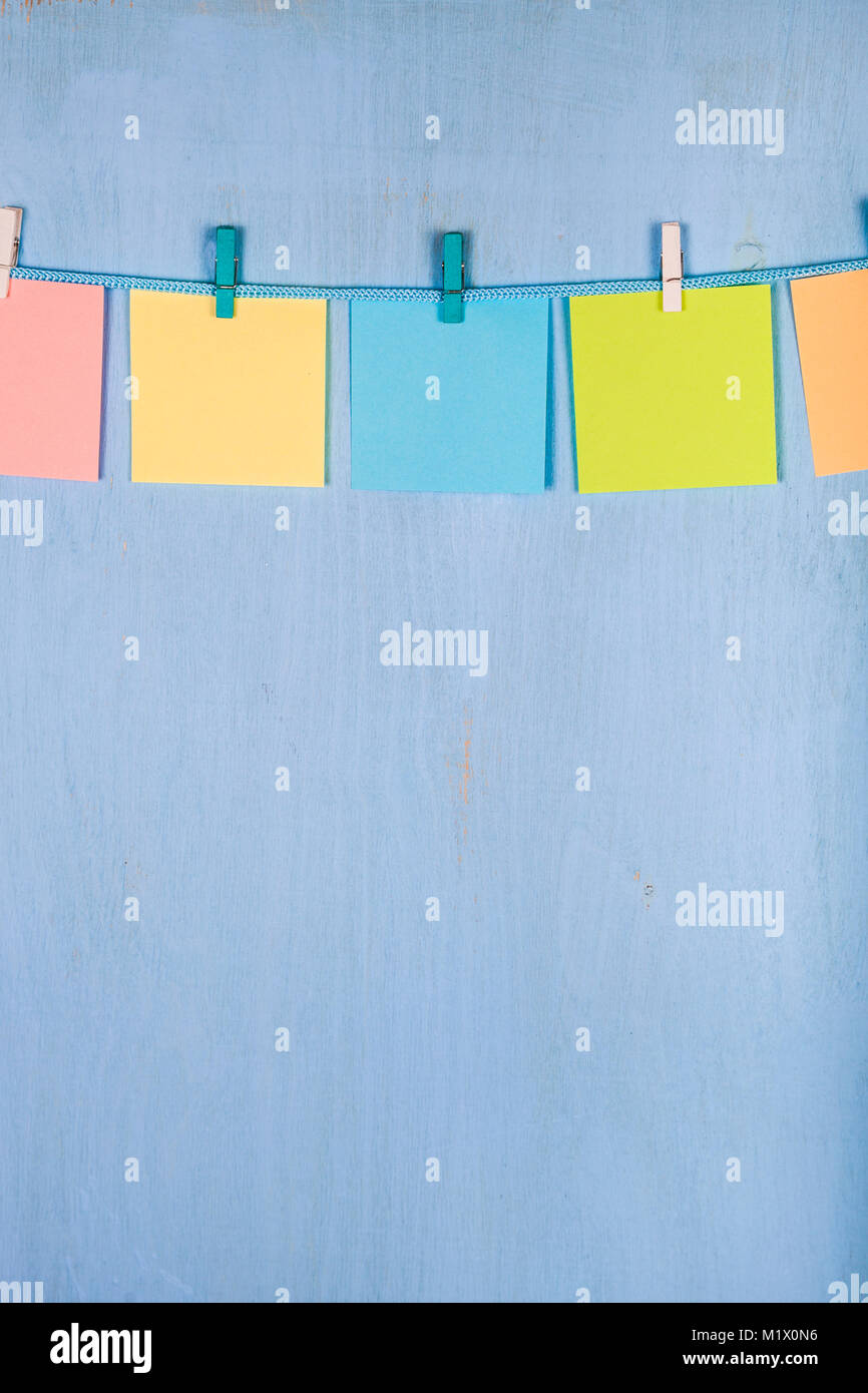 Five sheets of paper hang on a rope on a blue wooden background Stock ...