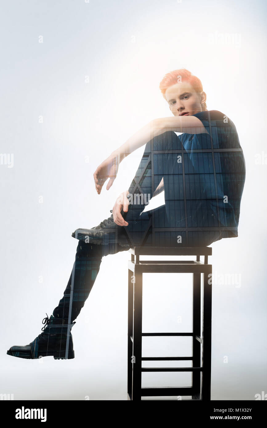 Serious professional model sitting on the chair and looking straight ...