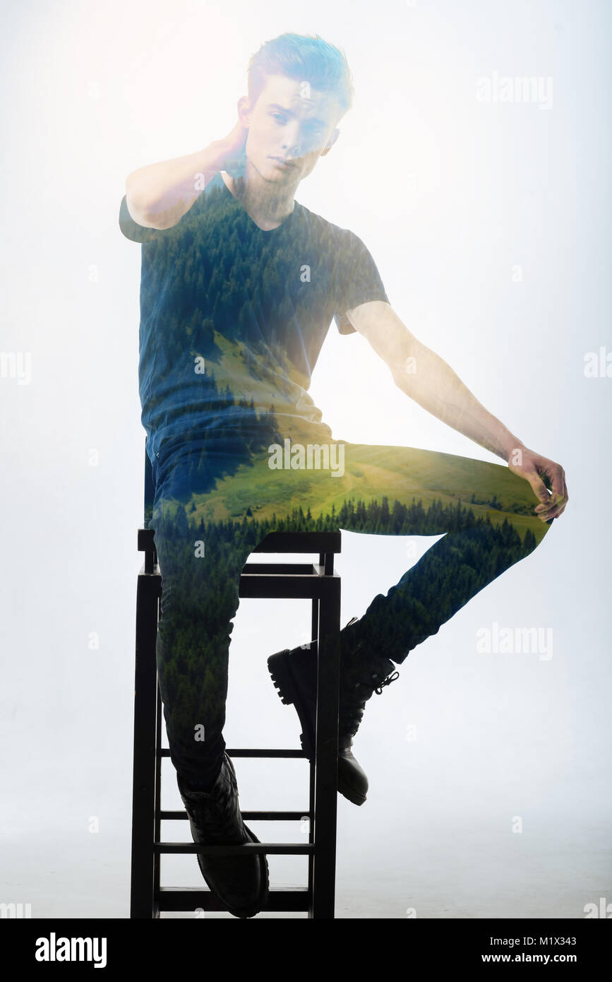Handsome confident man sitting on the chair and posing Stock Photo - Alamy