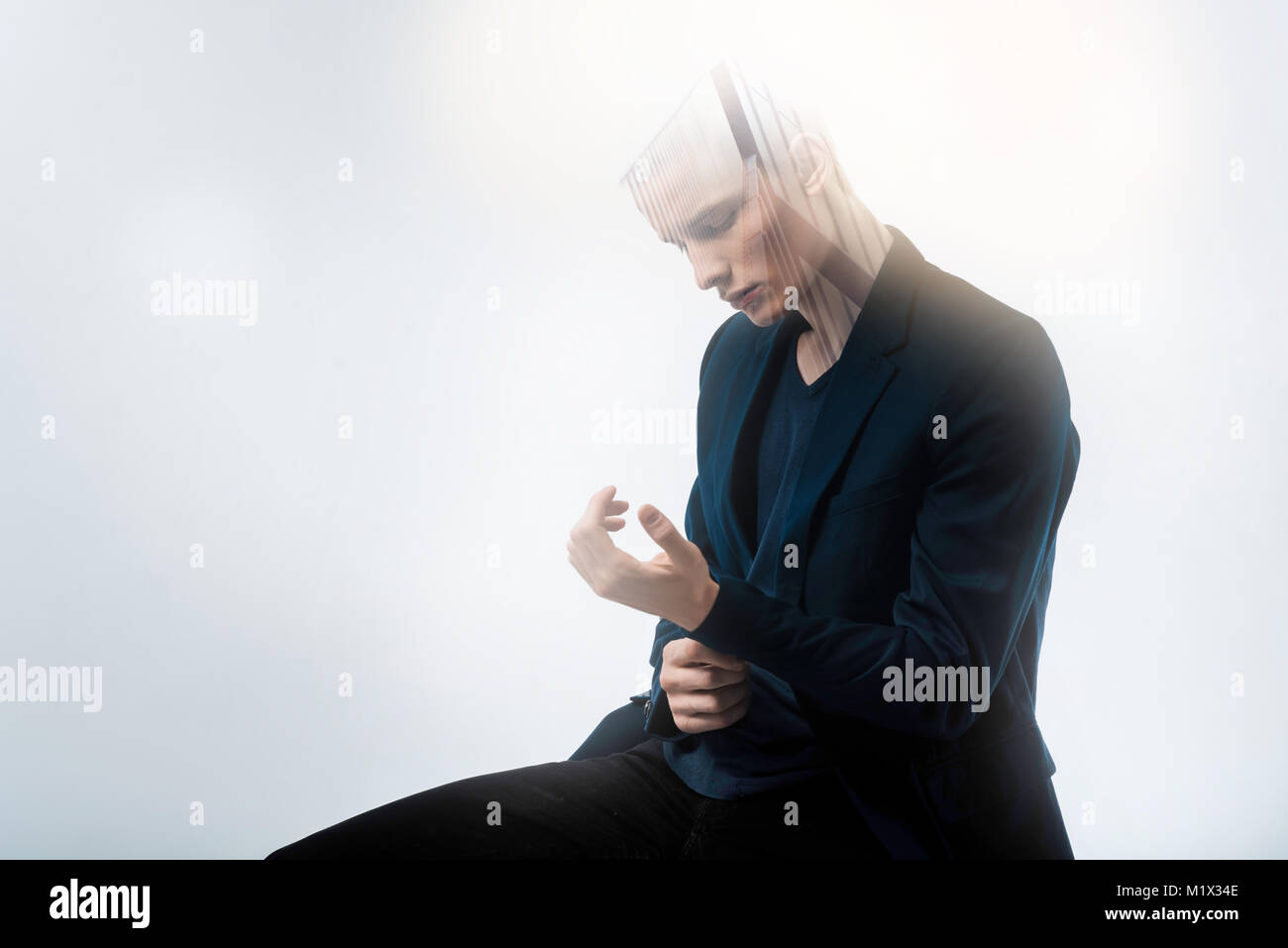 Concentrated sad man looking at hands and thinking Stock Photo - Alamy