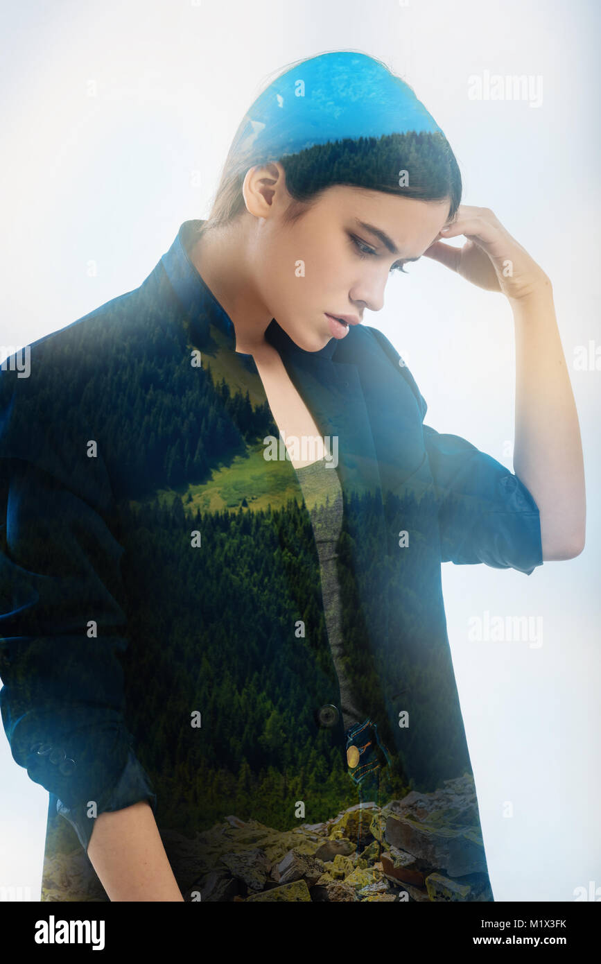 Deep stylish woman looking down holding hand near head Stock Photo - Alamy