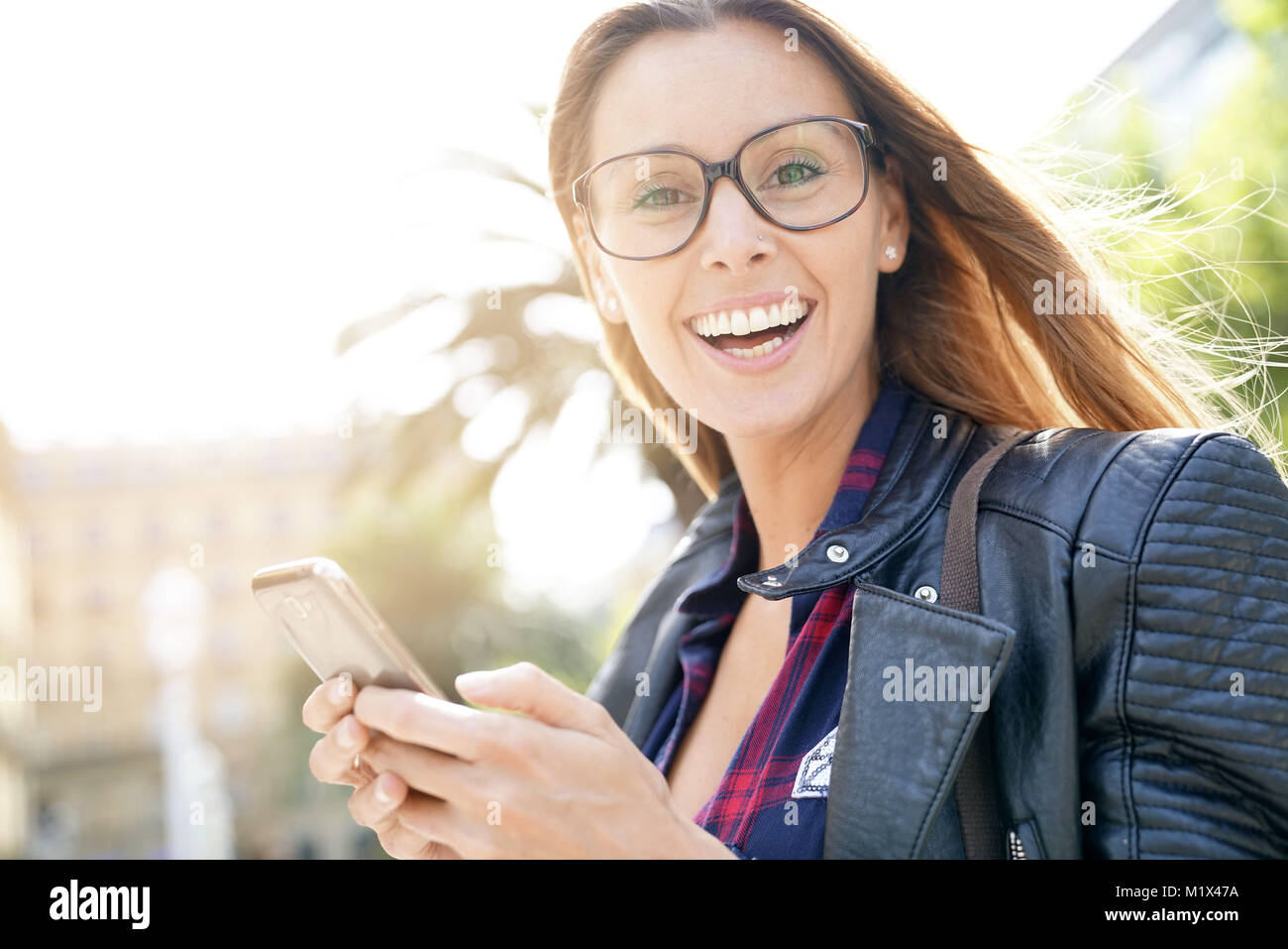 Portrait of trendy girl in town using smartphone Stock Photo - Alamy