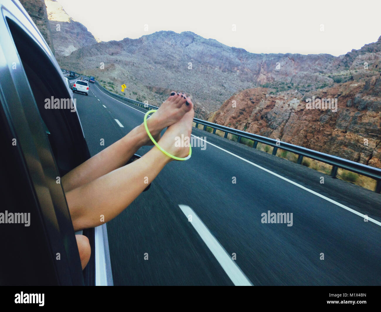 Legs out of a car window on a roadtrip Stock Photo - Alamy
