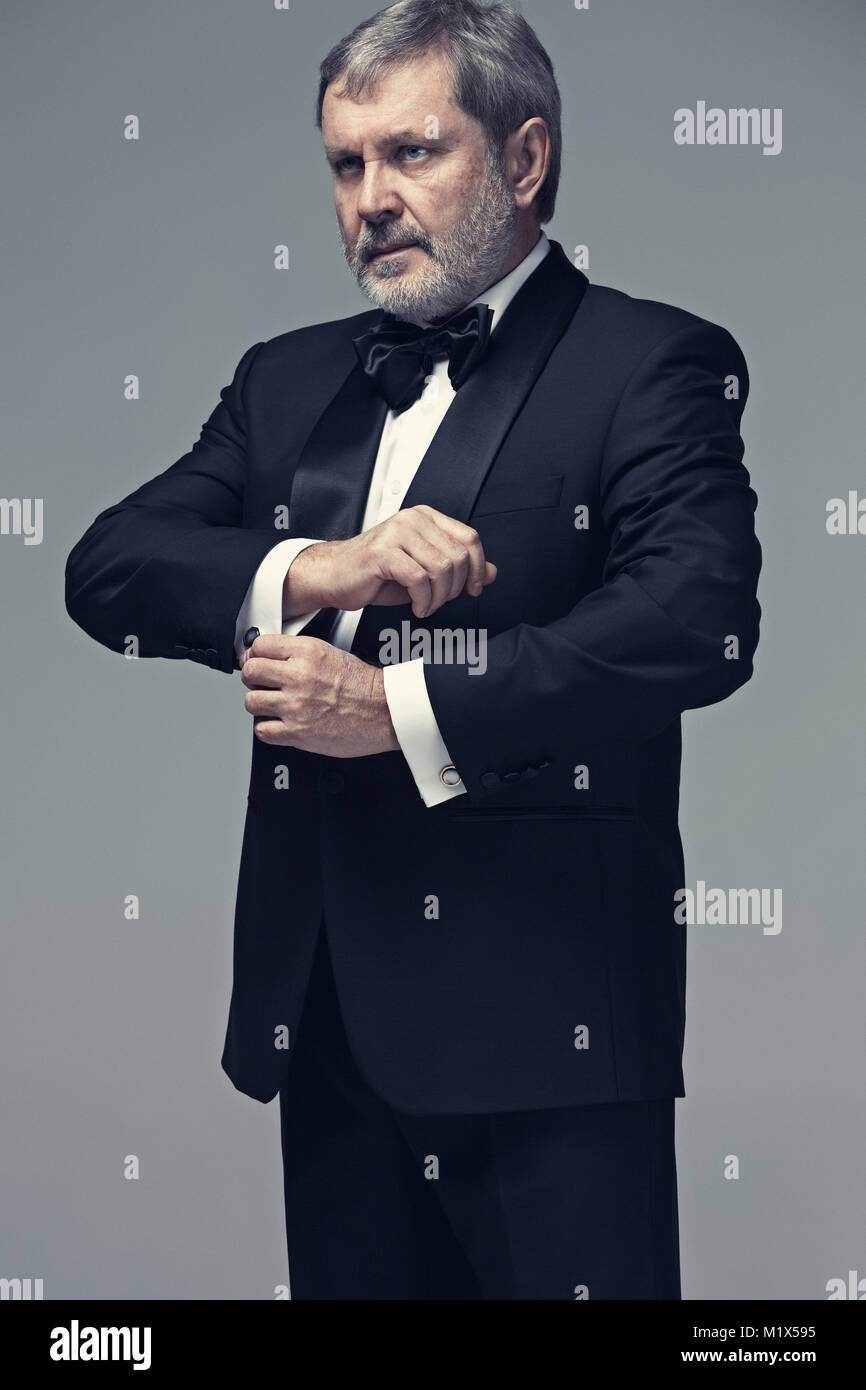 Middle aged male adult wearing a suit isolated on gray Stock Photo - Alamy