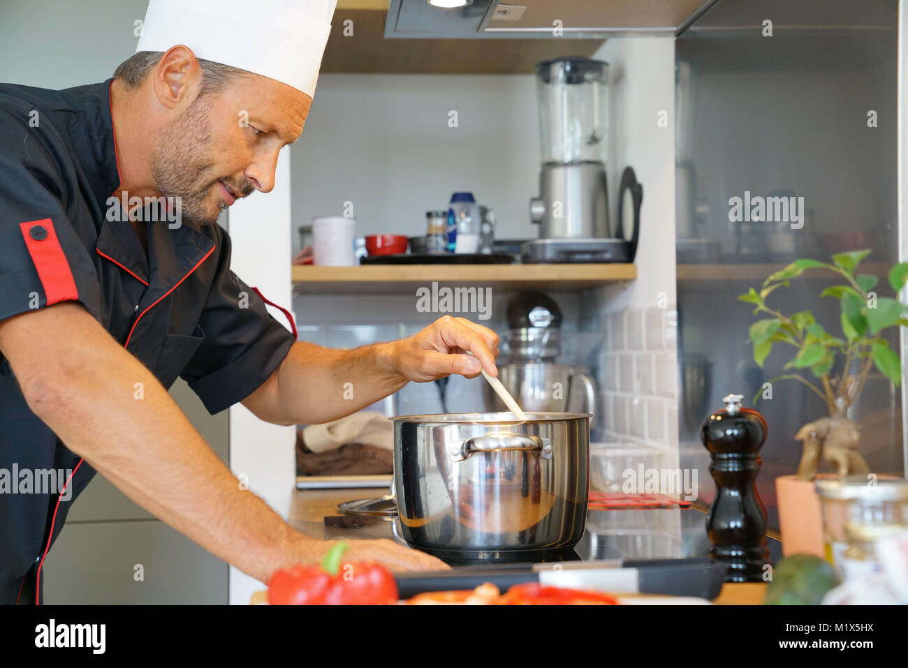Chef by the stove stiring pasta in boiling water Stock Photo - Alamy