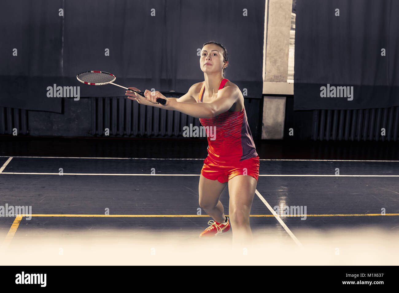 Young woman playing badminton at gym Stock Photo - Alamy