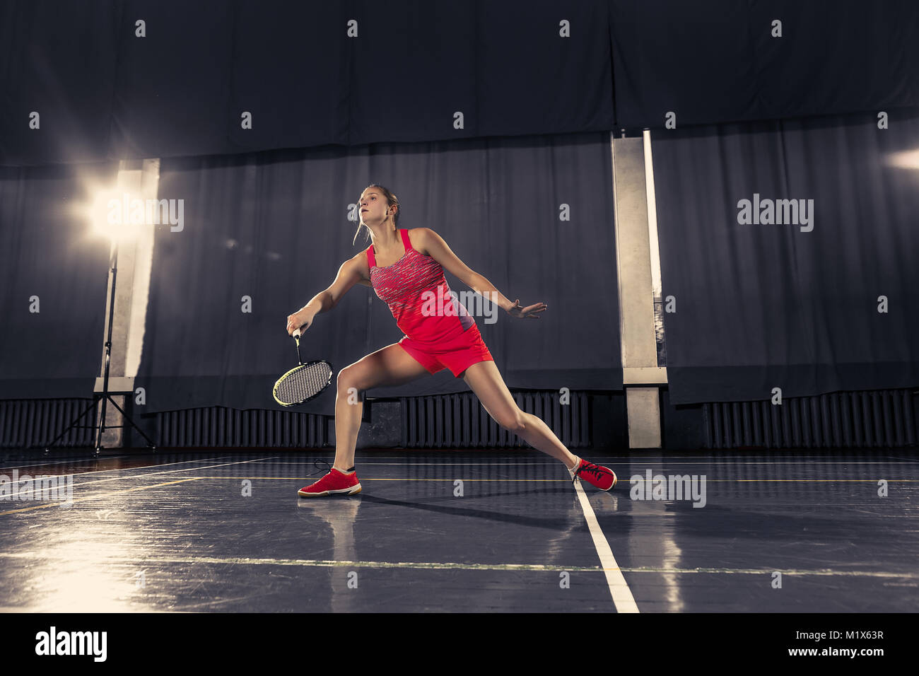 Young woman playing badminton at gym Stock Photo - Alamy