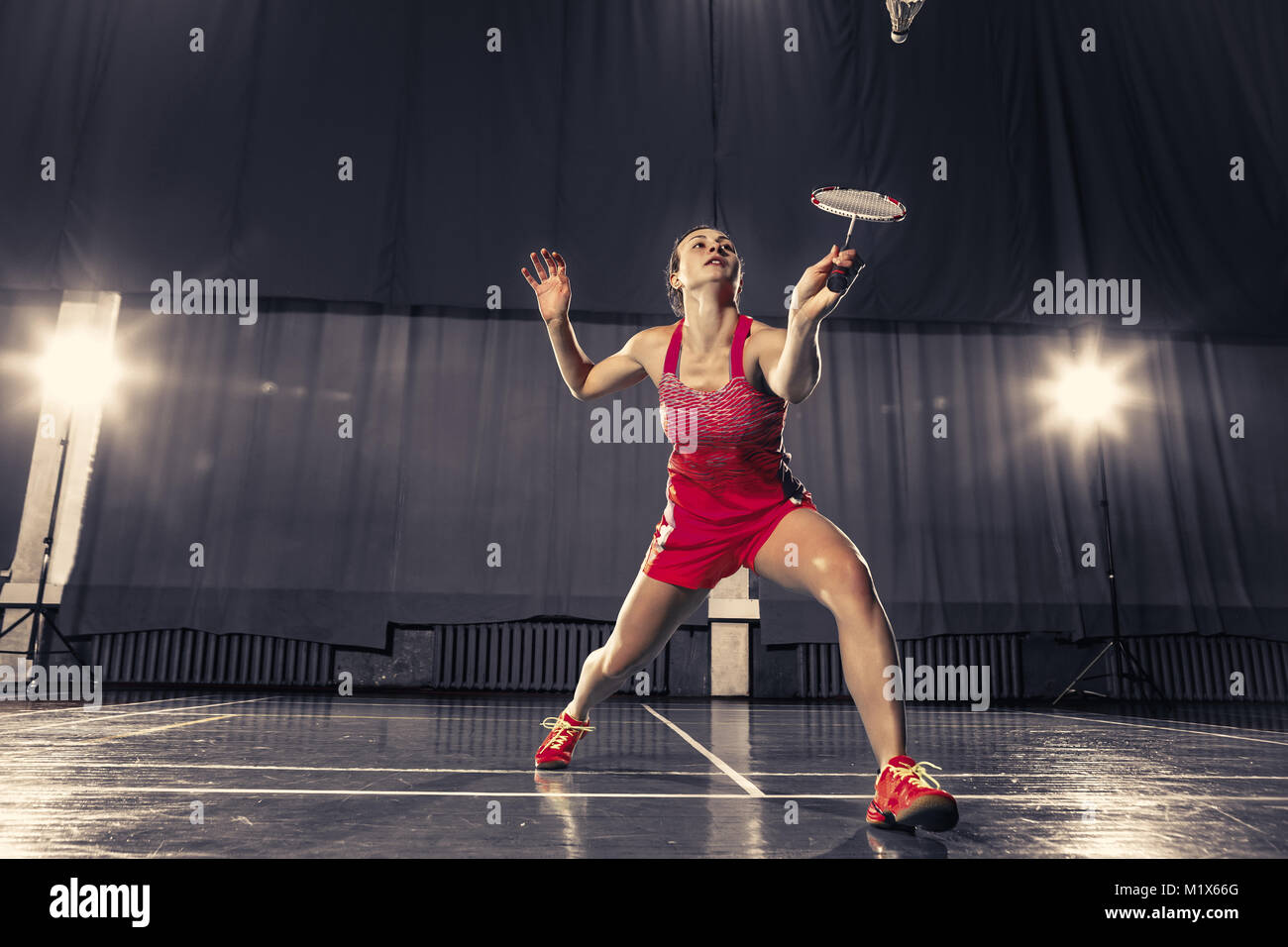 Young woman playing badminton at gym Stock Photo - Alamy