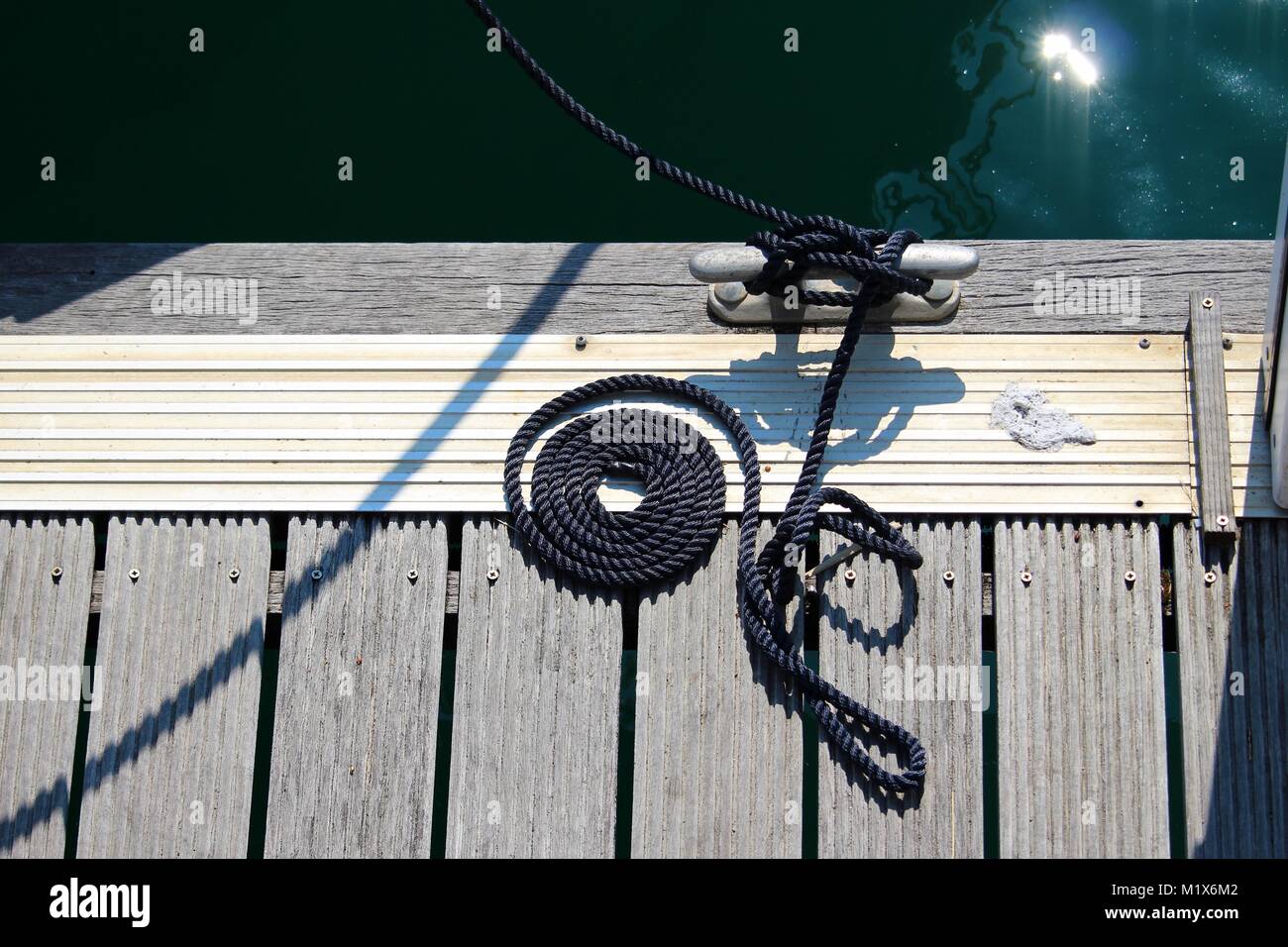 A tied rope on the docks of the ocean Stock Photo - Alamy