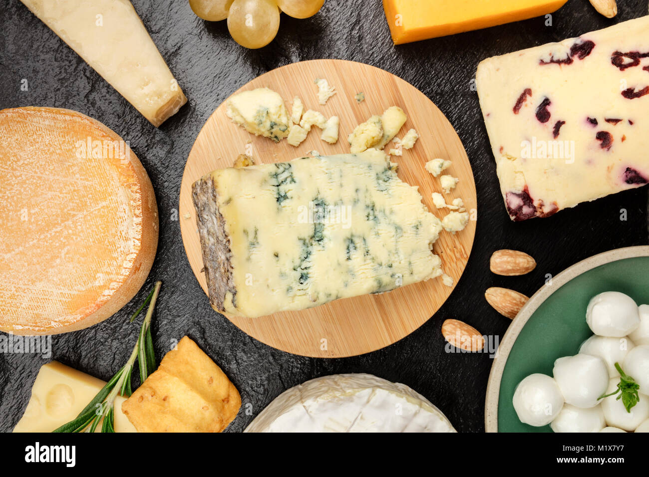 An assortment of various types of cheese, shot from above on a black ...