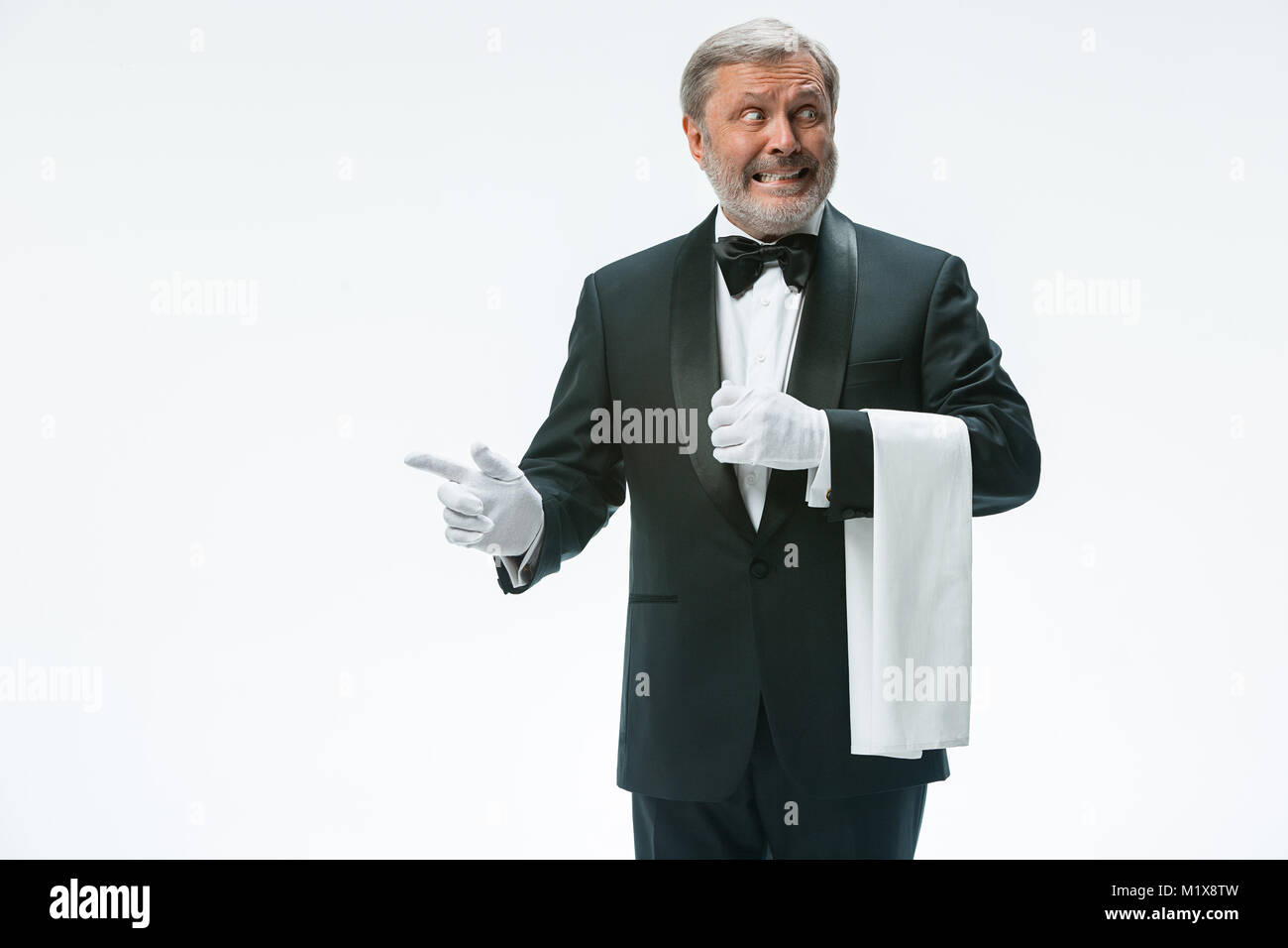 Senior waiter holding white towel Stock Photo - Alamy