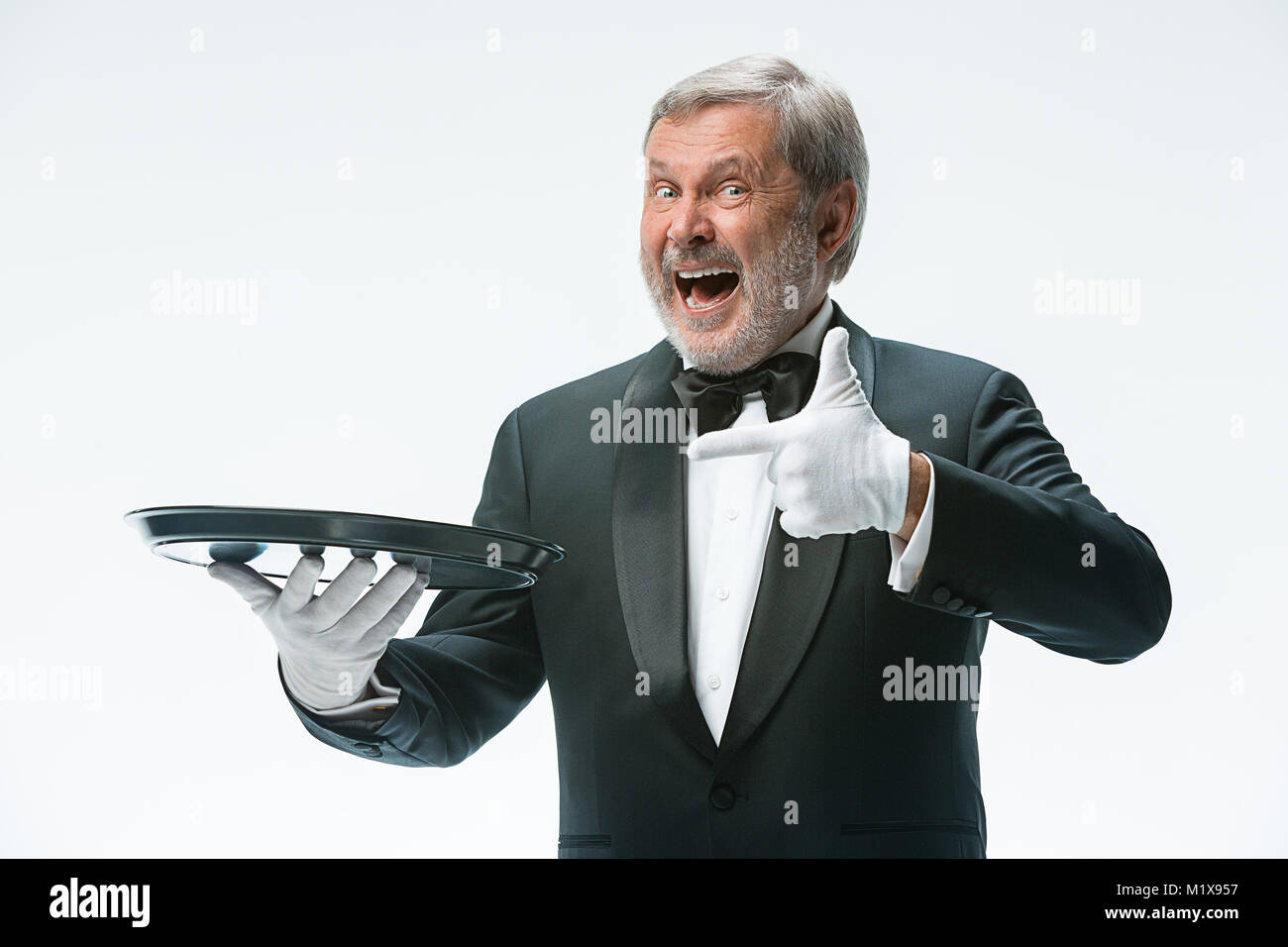 Senior waiter holding tray Stock Photo - Alamy