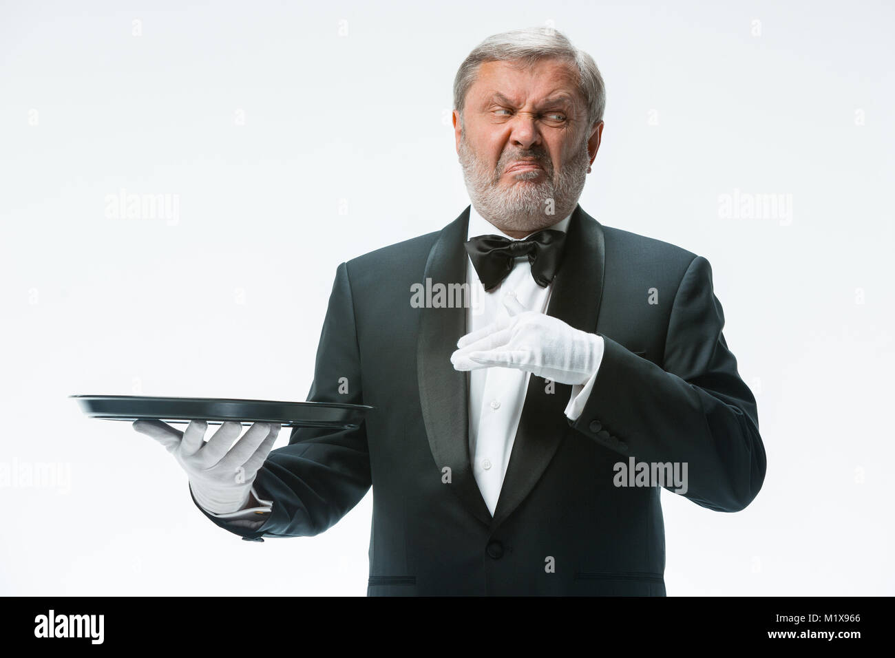 Senior waiter holding tray Stock Photo - Alamy