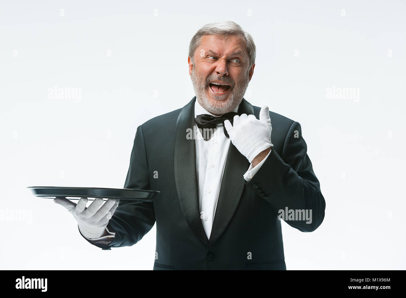 Senior waiter holding tray Stock Photo - Alamy