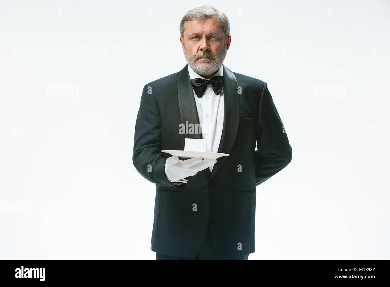 Senior waiter holding tray Stock Photo - Alamy