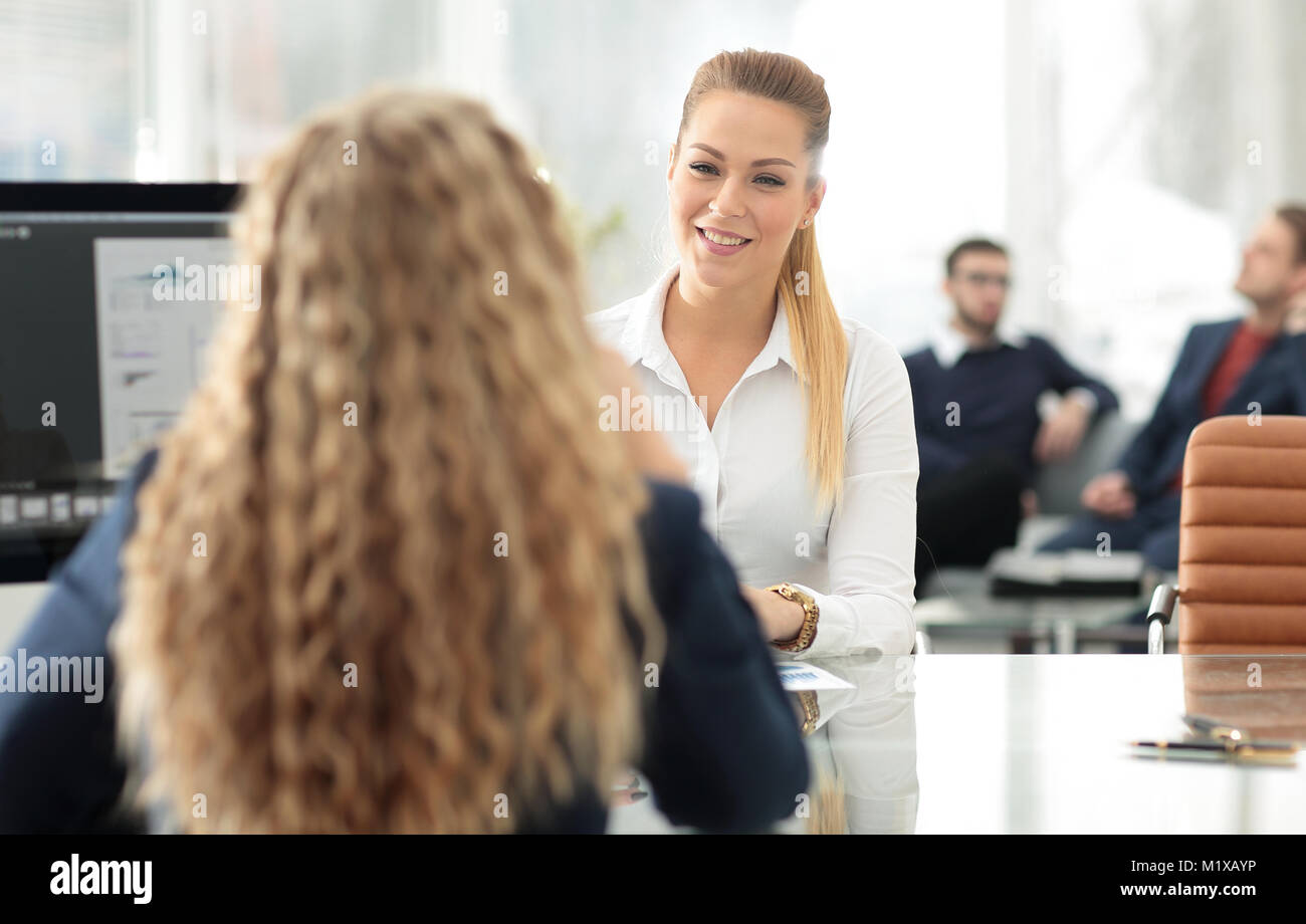 employees discussing ideas sitting at his Desk Stock Photo - Alamy