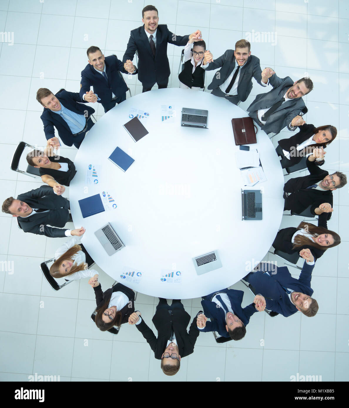 large business team sitting at the round table and raising his hands up ...