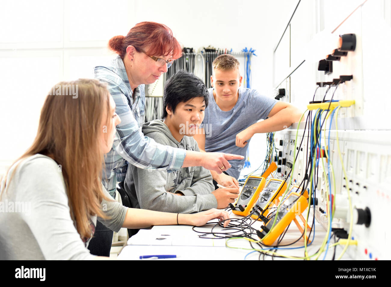 Group of young people in technical vocational training with teacher ...