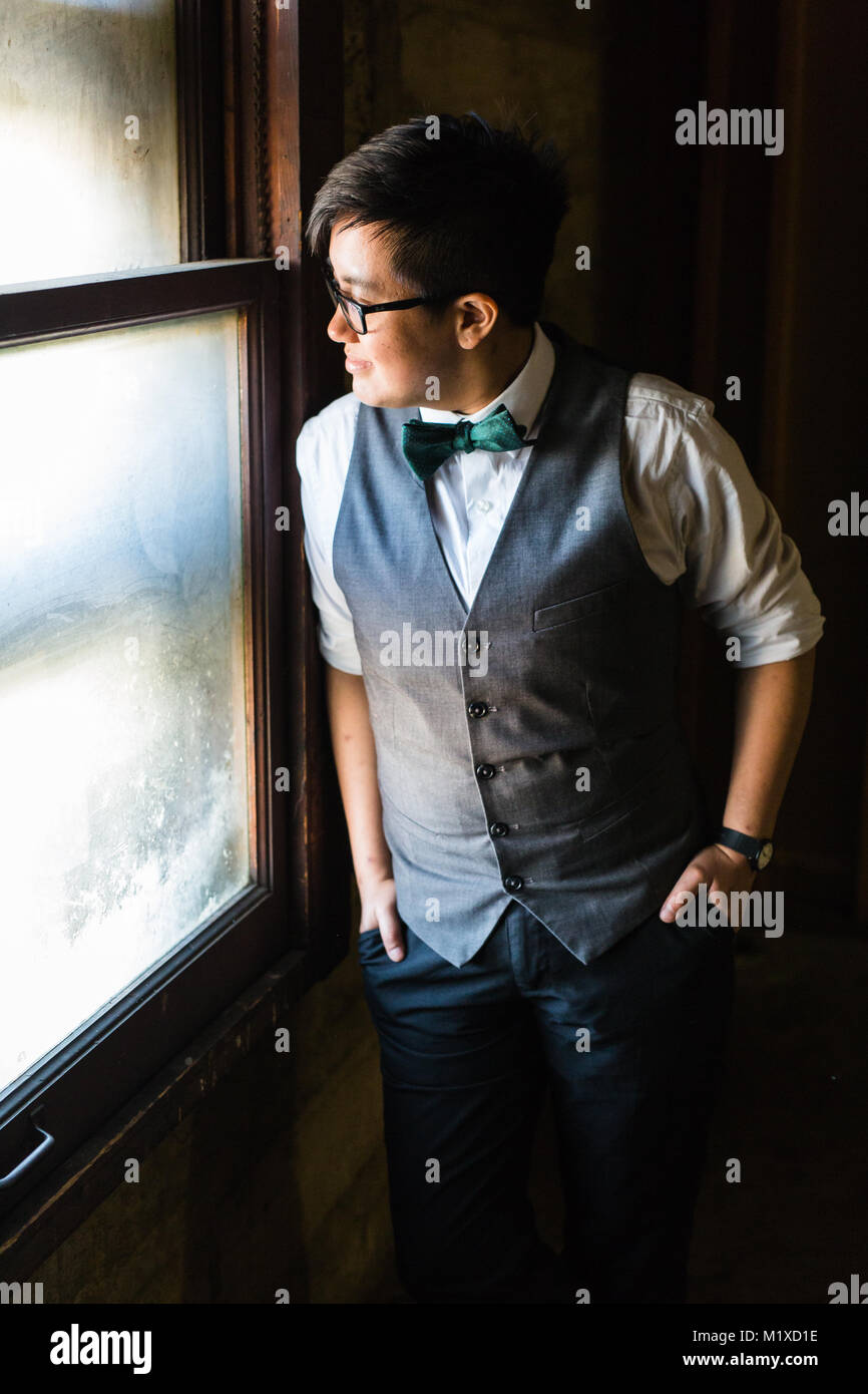Young transgender man in formal clothing poses in a grungy urban ...