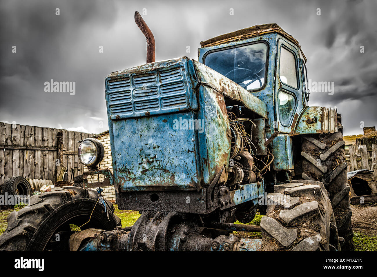Old rusty broken rural tractor stands in the backyard Stock Photo - Alamy
