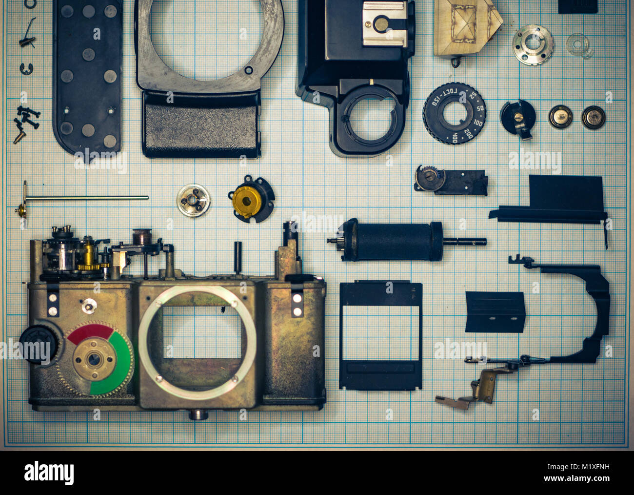 parts are completely disassembled old retro film SLR camera on graph ...