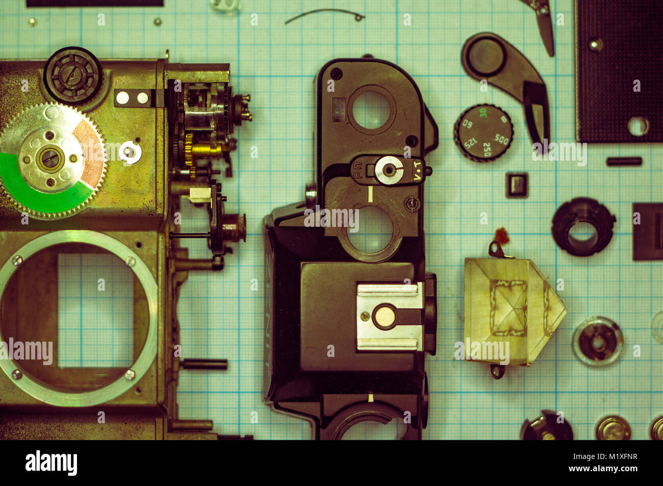 parts are completely disassembled old retro film SLR camera on graph ...