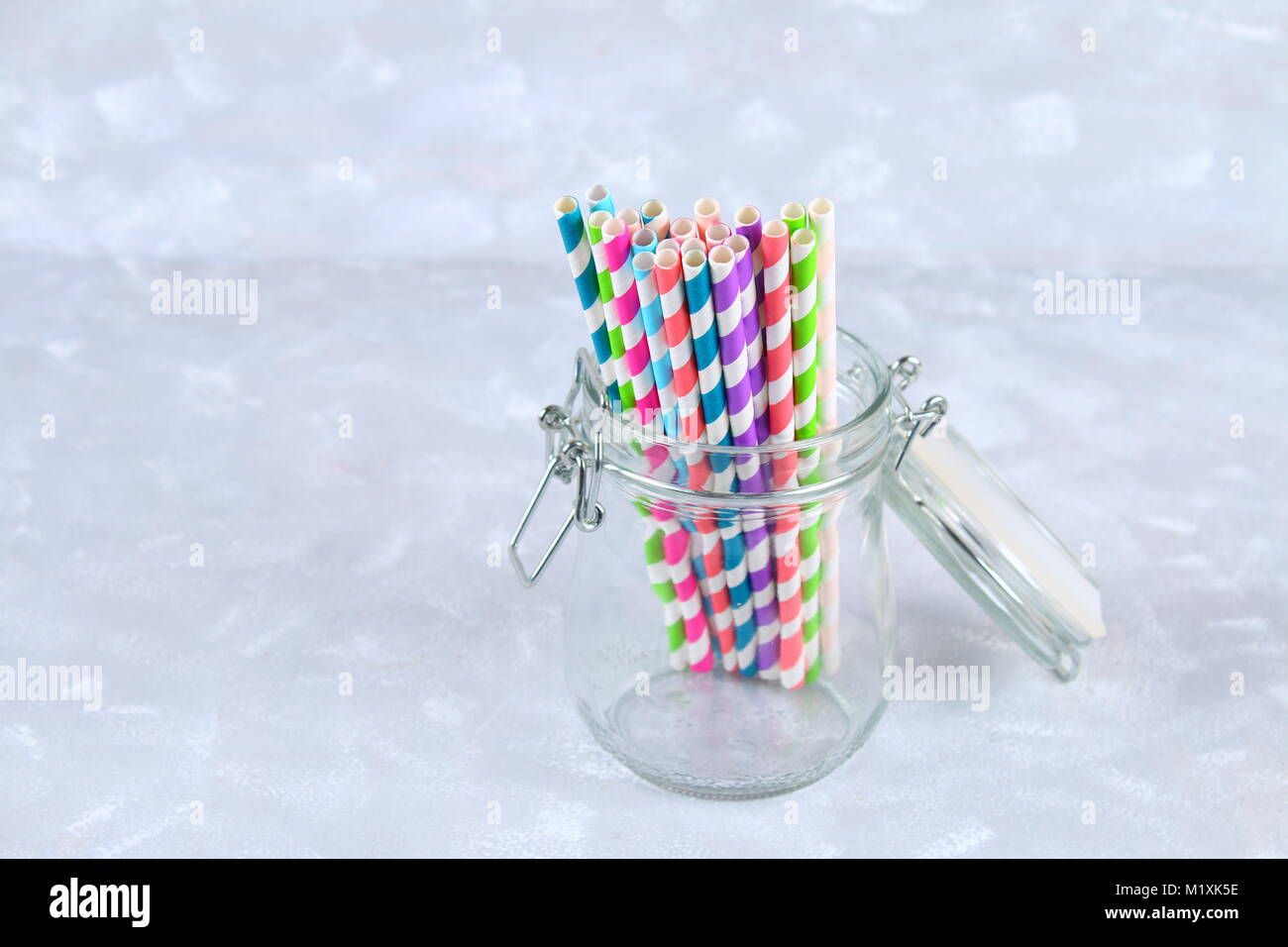 colorful striped paper disposable tubes in a jar on a gray background ...