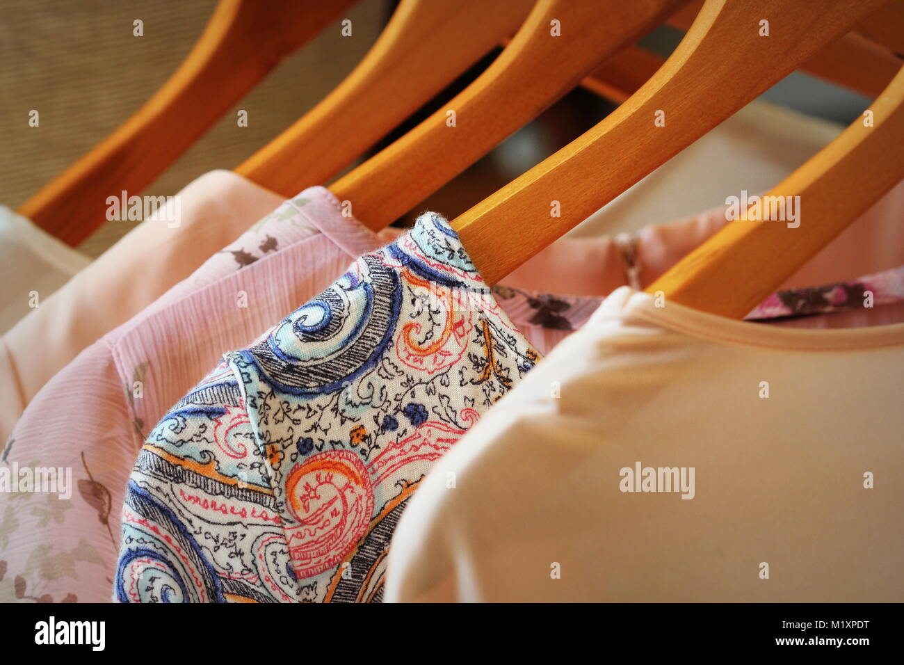 collection of women's clothes hanging on rack for sale Stock Photo - Alamy