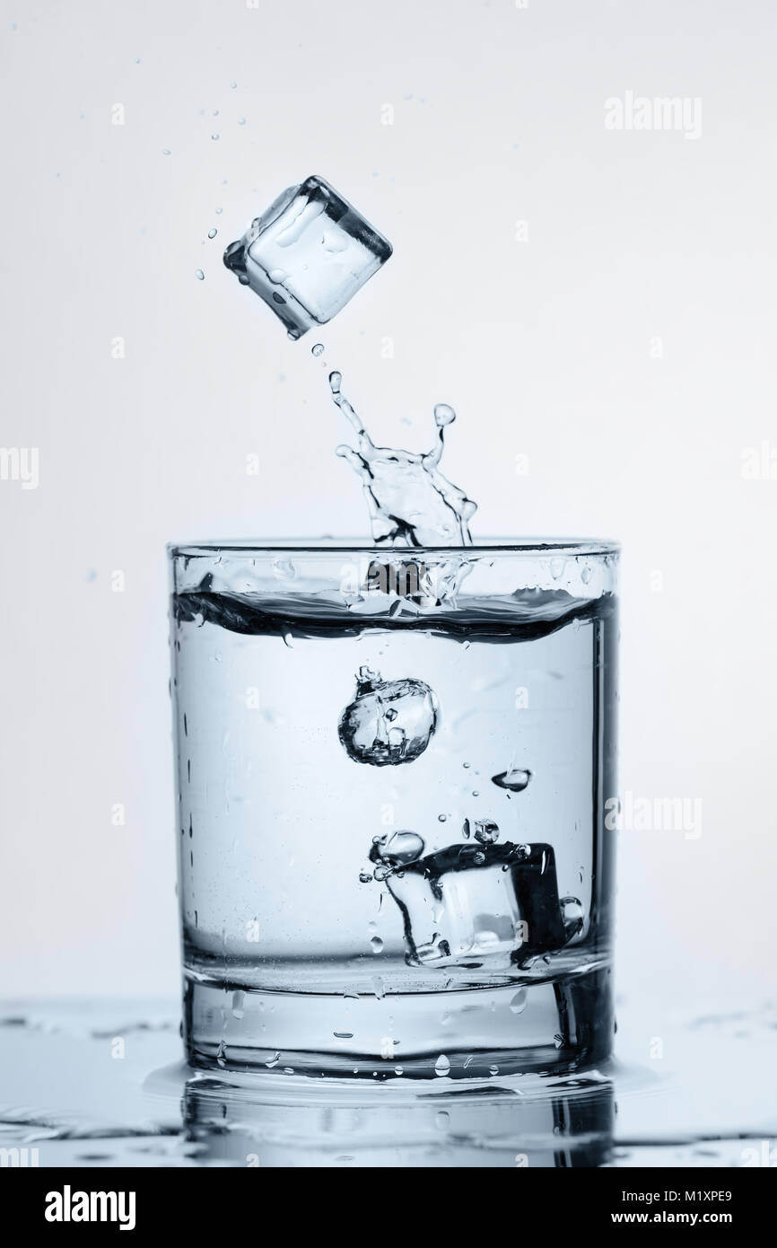 Ice cubes are dropping in to the glass of pure water Stock Photo - Alamy