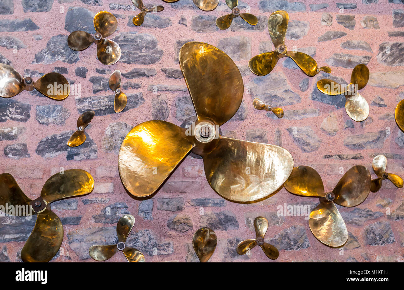 Several Sizes of ship propellers on the wall Stock Photo - Alamy