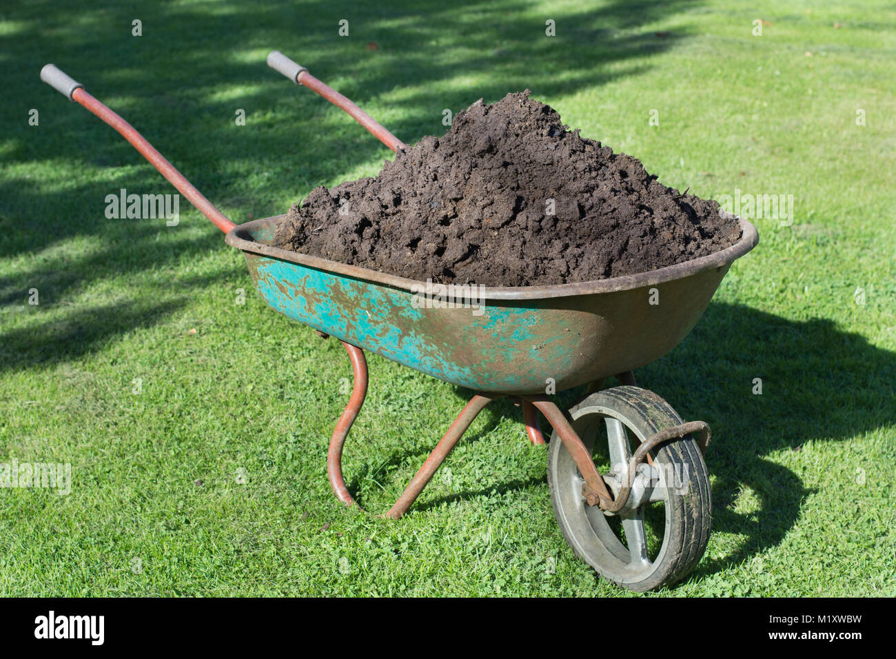 Garden-wheelbarrow filled with soil on a farm. Outdoors Stock Photo - Alamy
