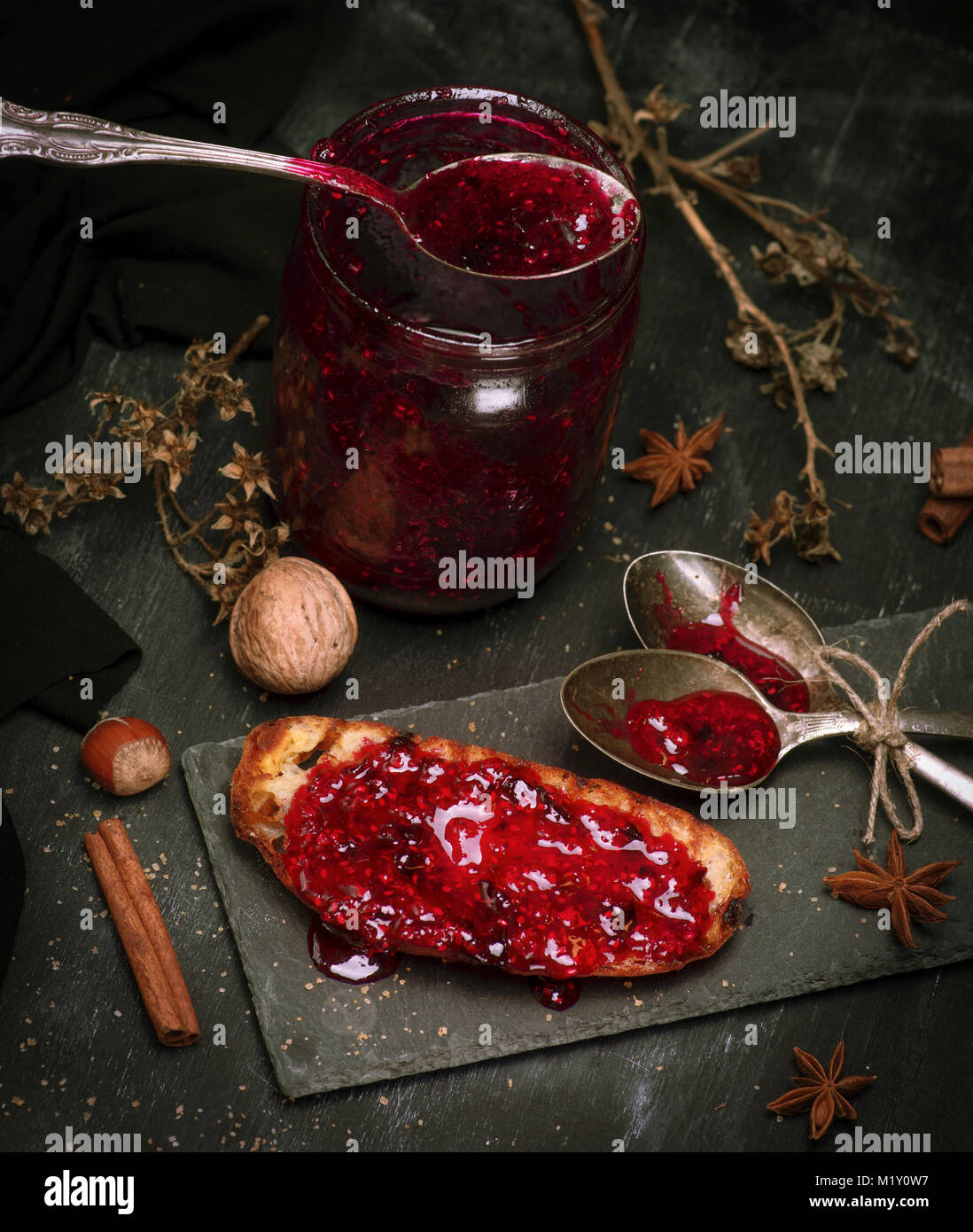 toast with raspberry jam and empty jam jar with an iron spoon on a ...
