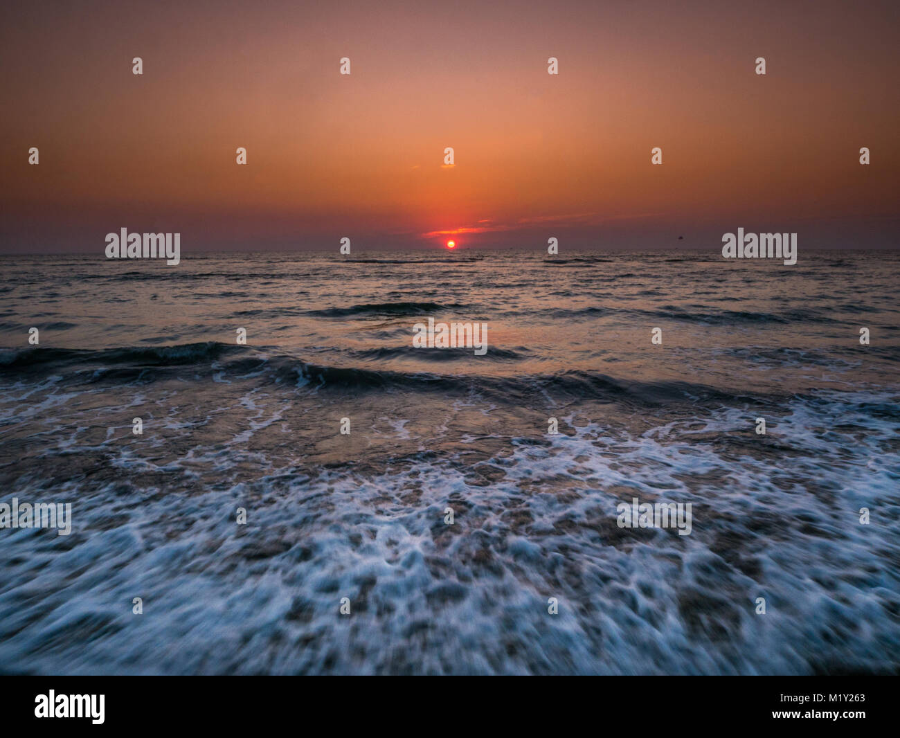 Colorful sunrise sunset over the sea ocean waves Stock Photo - Alamy
