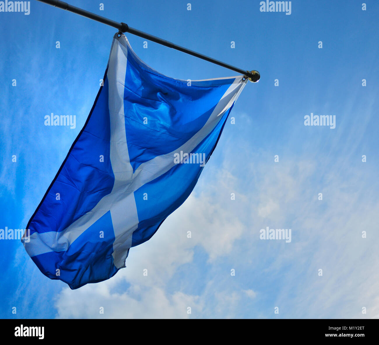 A Scottish Saltire flag hanging from a building on a sunny day Stock ...
