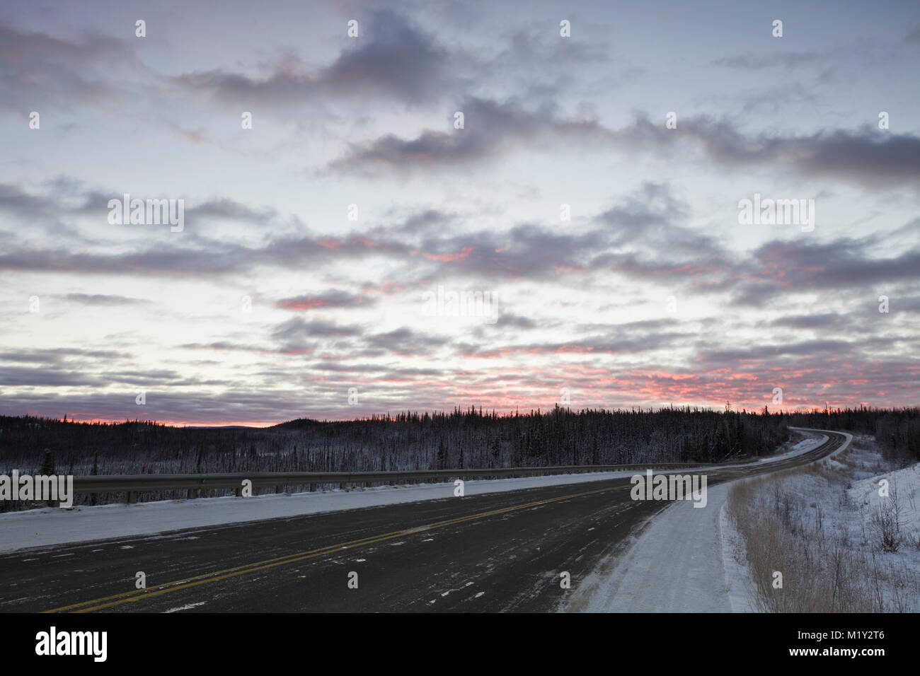 An early winter sunrise creates a pink alpenglow in the sky near the ...