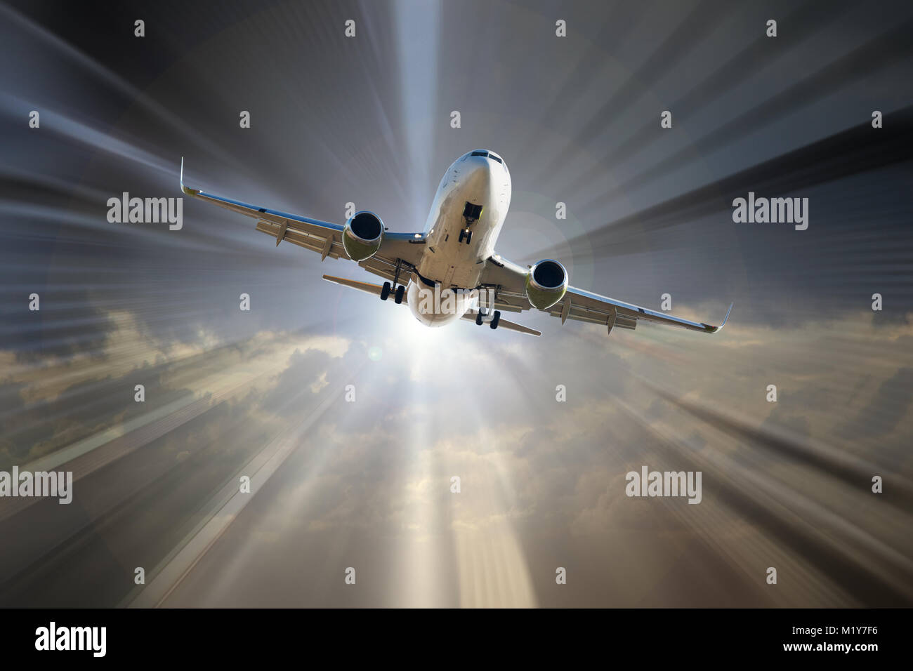 Big airplane taking up motion in sky on sunbeams background Stock Photo ...