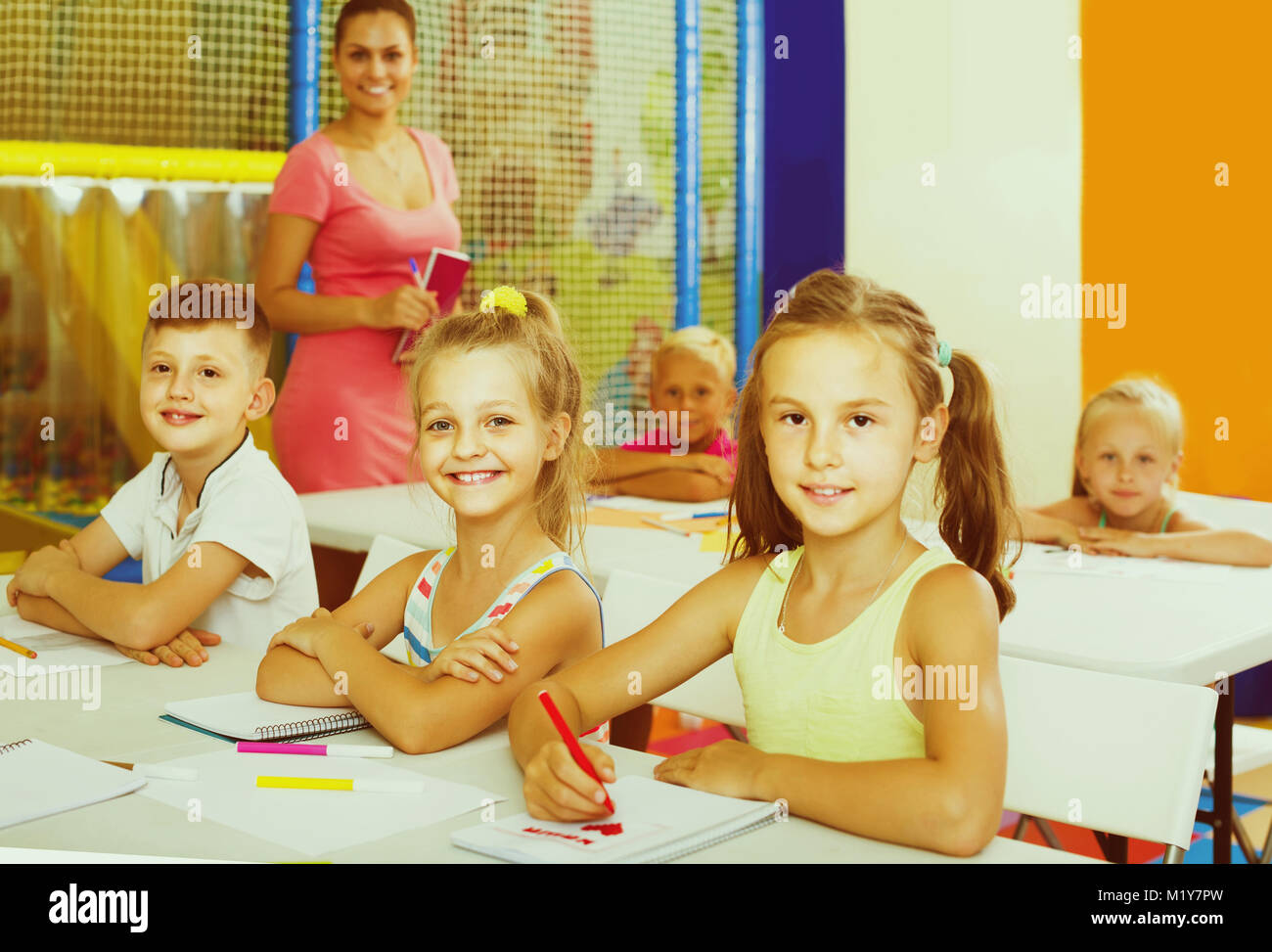 positive spanish children sitting together and studying in class at ...