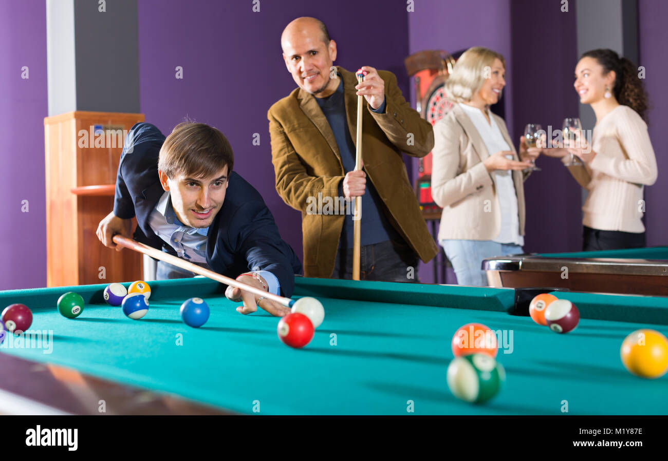 group of positive middle class people having pool game in billiard club ...