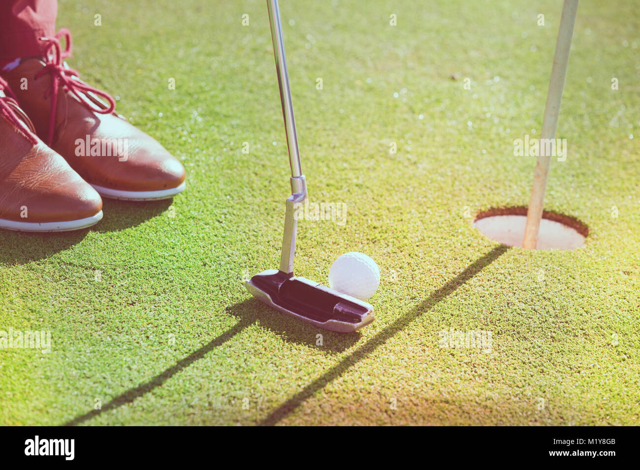 Male golf player focused before the final hit the ball in the hole ...
