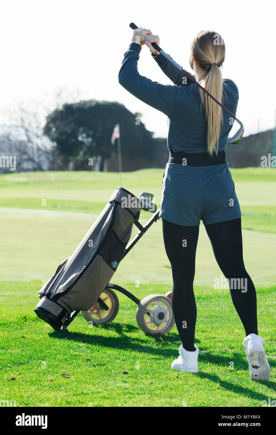 Young female golfer made successful hit at golf course Stock Photo - Alamy