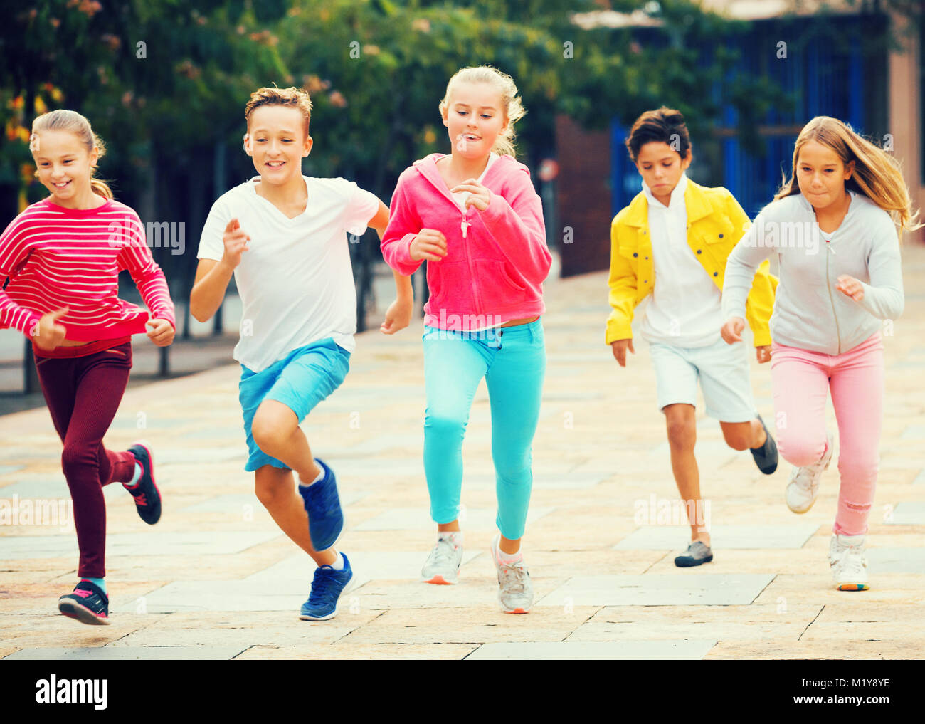 Company of active happy kids are jogning together in the park Stock ...