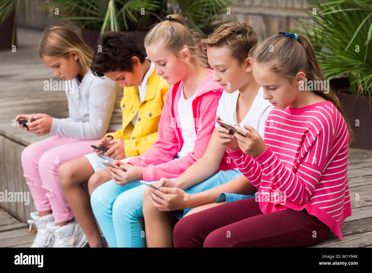 Children are playing on smartphone in the playground Stock Photo - Alamy