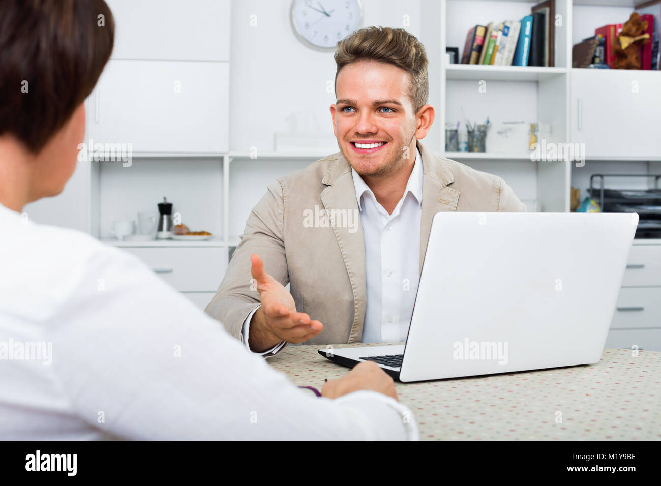 The young positive journalist with white laptop interviews the elderly ...
