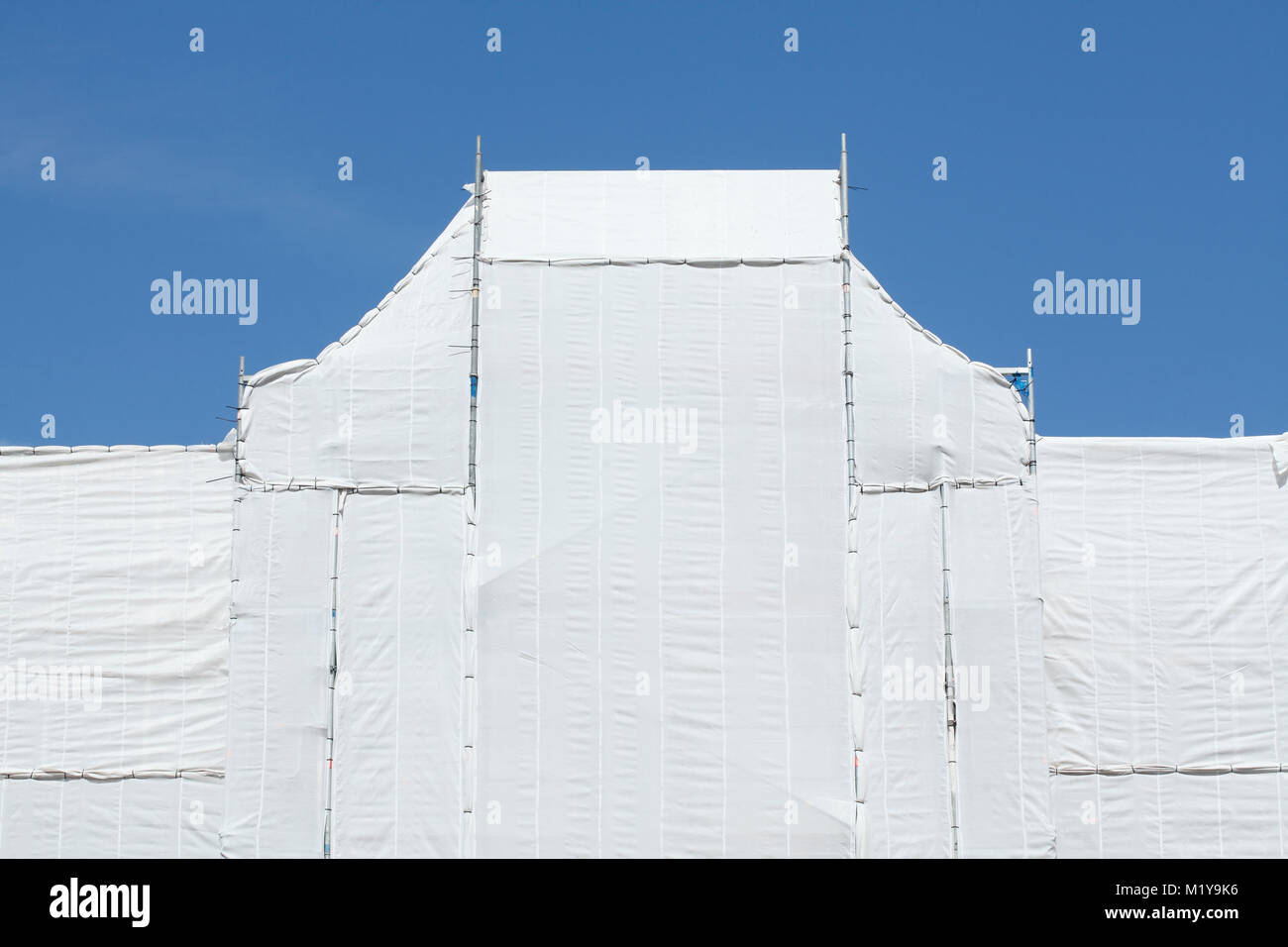 with tarpaulins covered facade of a historical building, renovation ...