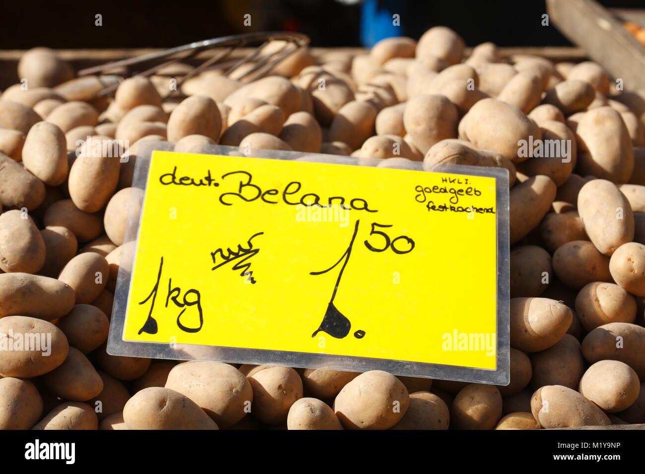 brown potatoes on a market stall with yellow price tag Stock Photo - Alamy