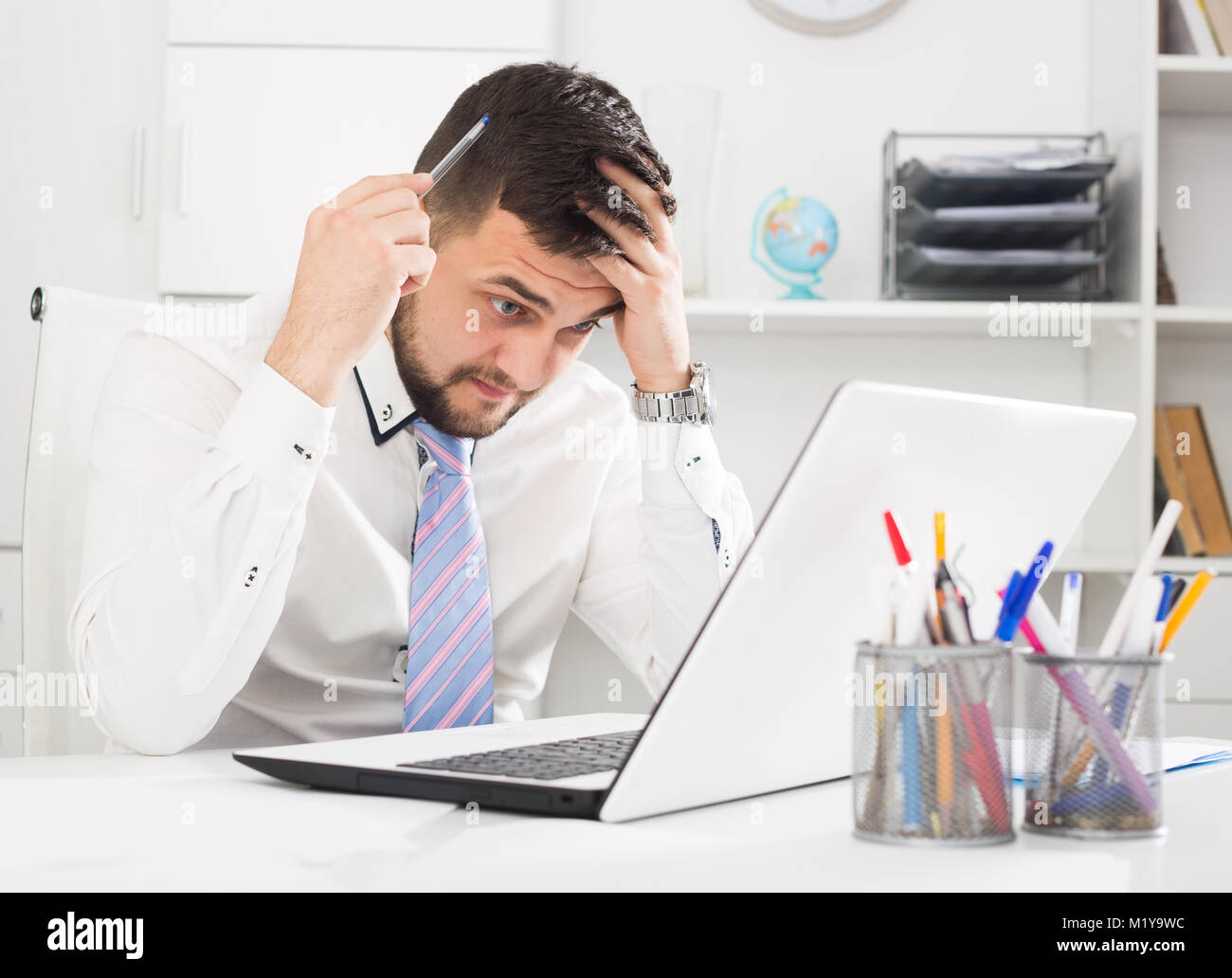 Male employee having complicated issue in project in office Stock Photo ...