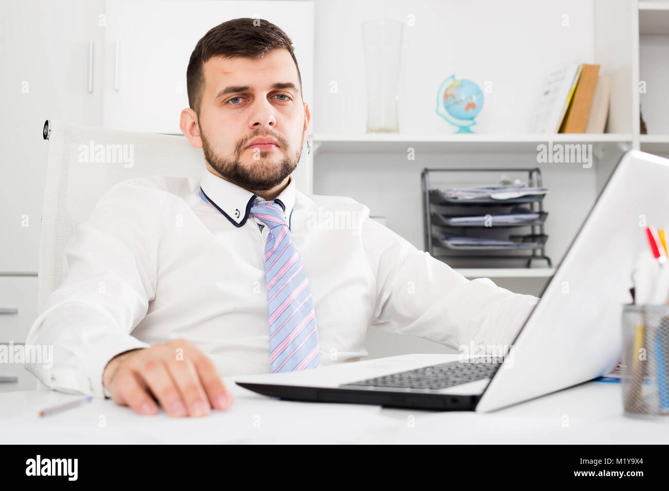 Young male worker working productively on project in office Stock Photo ...