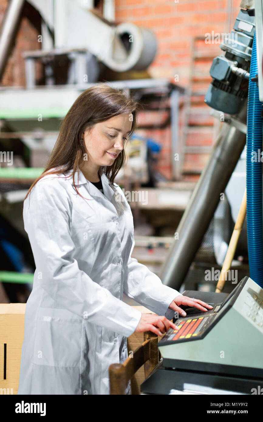 Smiling positive female engineer with washing and crushing olive ...